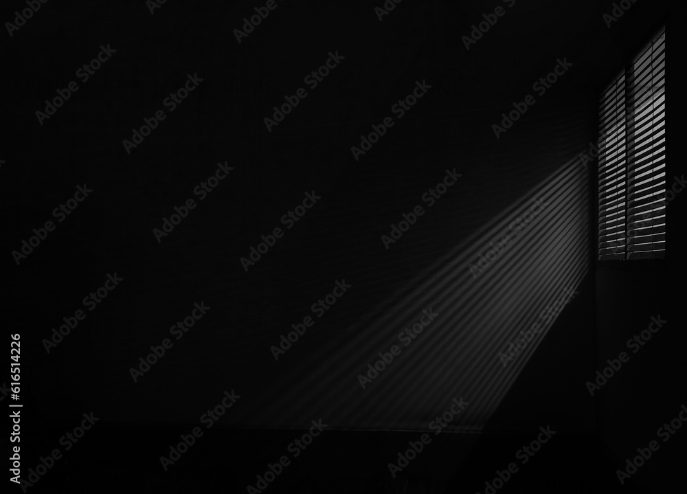 interior of dark room. shadow of the rays falling on the wall through ...