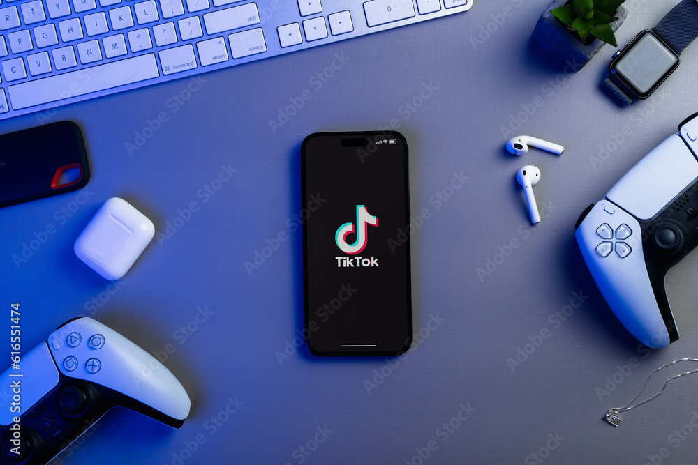 Tik Tok app on the smartphone iPhone 14 Pro screen with PS5 video game ...