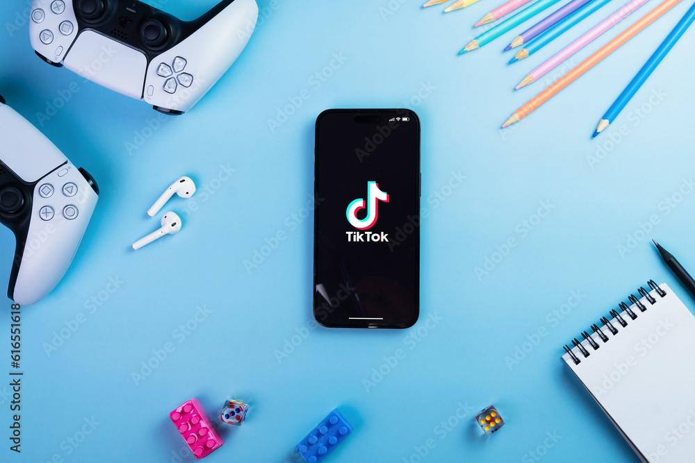 Tik Tok app on the smartphone iPhone 14 Pro screen on blue table with ...