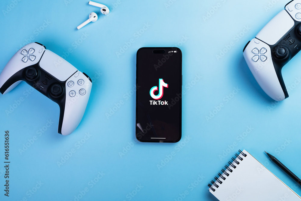 Tik Tok app on the smartphone iPhone 14 Pro screen on blue table with ...