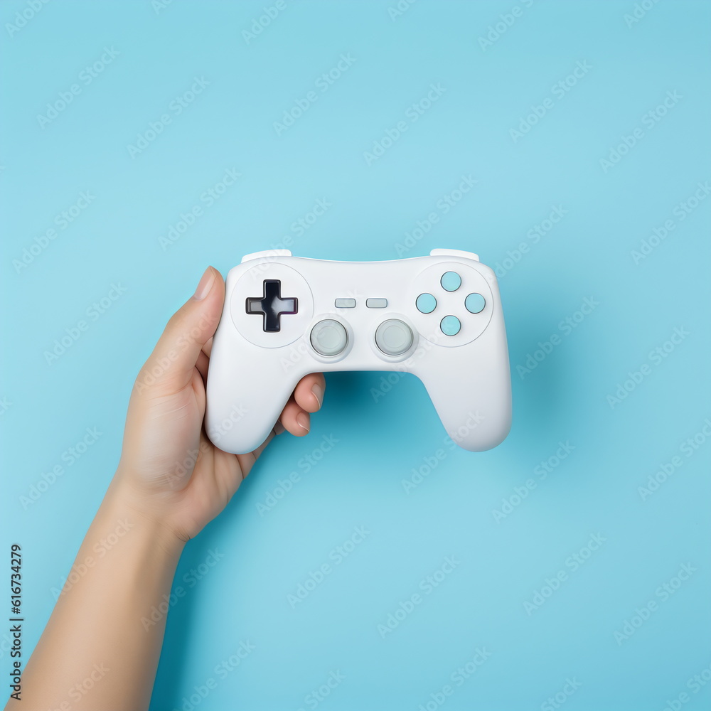 hand holding game controller isolated on plain blue studio background ...