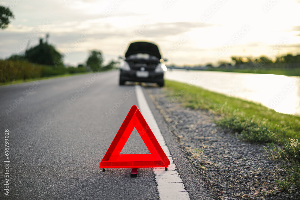 Red emergency stop sign with broken down car on the road waiting to be ...
