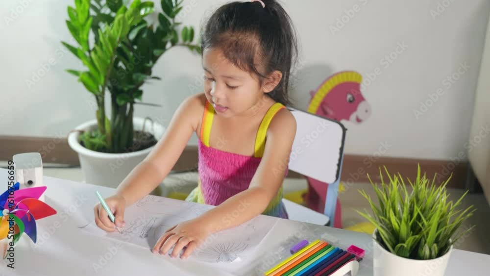 Child little girl drawing cartoon on paper before paint the color ...