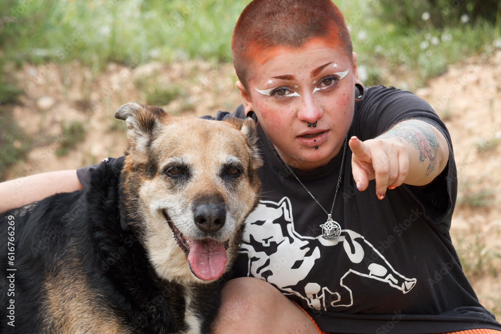 Foto de Mujer maquillada junto a perro adulto señalando y mirando a ...