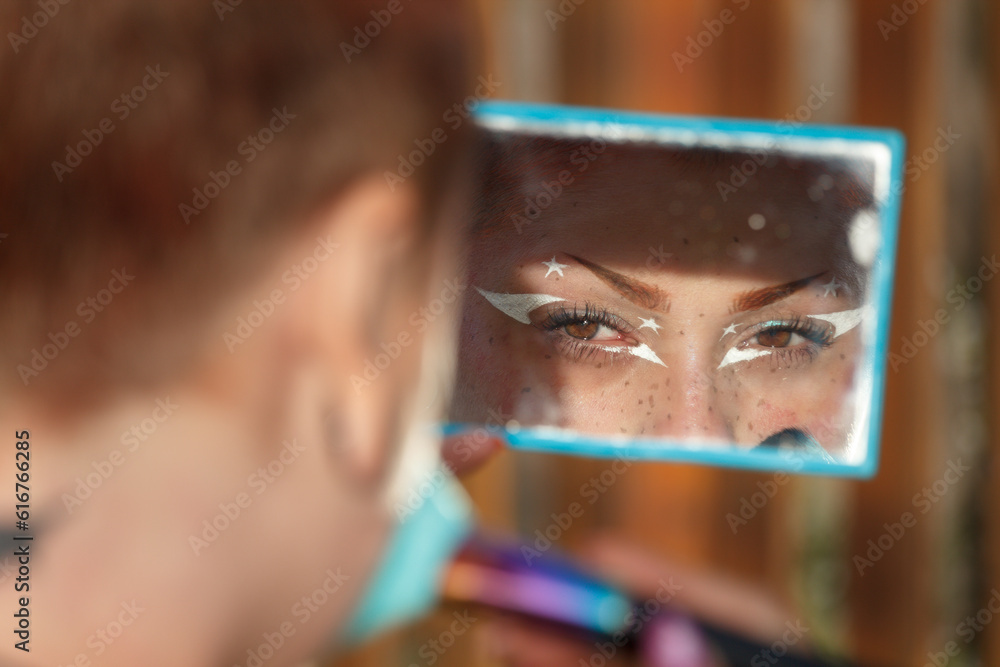 Reflejo en el espejo durante el maquillaje facial con foco en los ojos ...