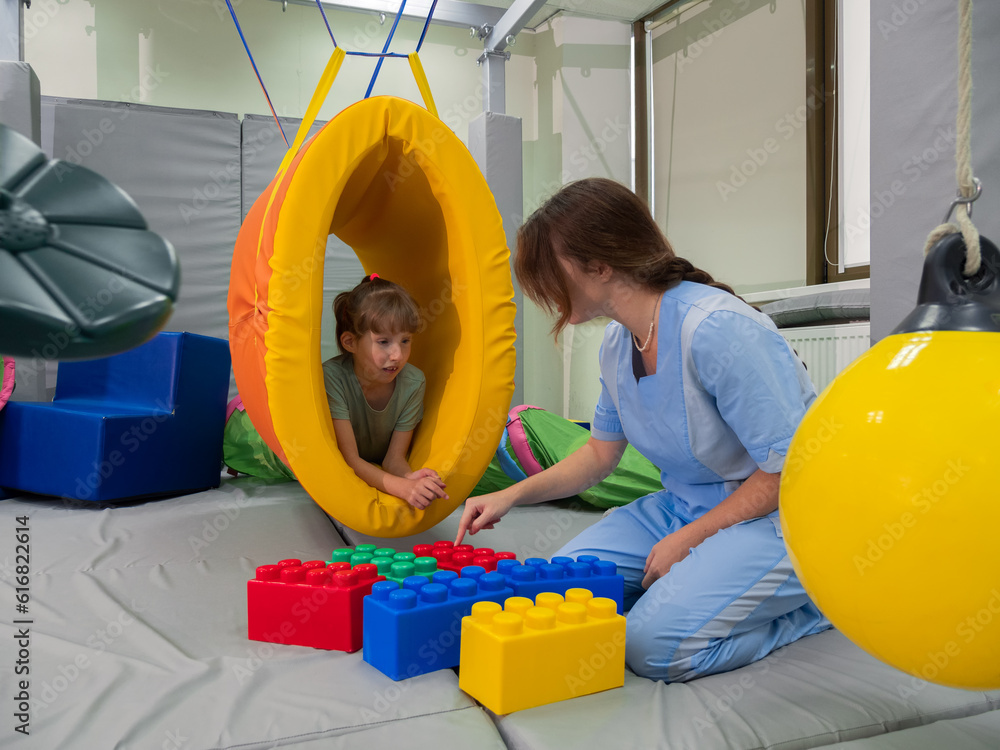 Child girl in roller tonnel during sensory integration session. child ...