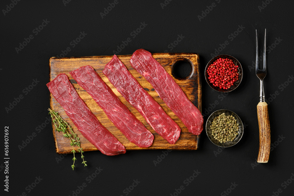 Overhead view of raw beef strips on black background Stock Photo ...