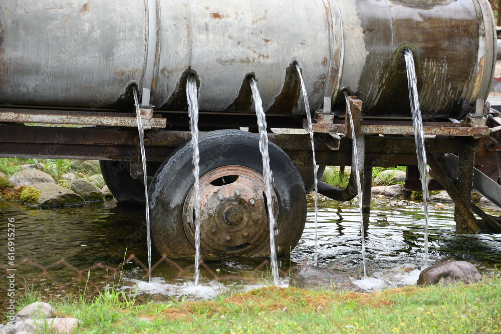 Aus landwirtschaftlichem Wassertank fließt aus Löchern wasser ab im ...