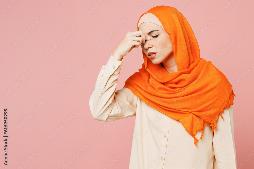 Young sad arabian asian muslim woman wear orange abaya hijab keep eyes ...