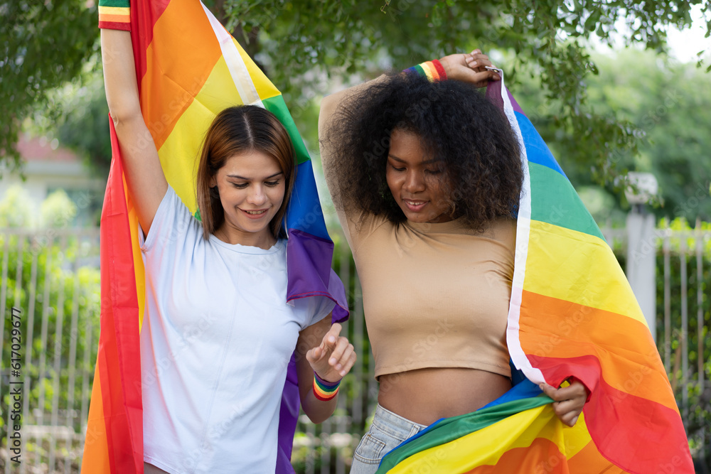 Multiracial Woman And Girlfriend Holding Rainbow Flag Happy Hug And