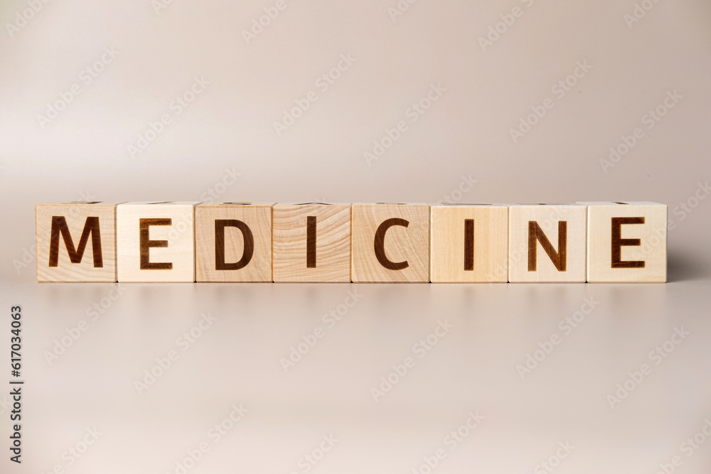 The word MEDICINE on wooden cubes on a beige neutral studio background ...
