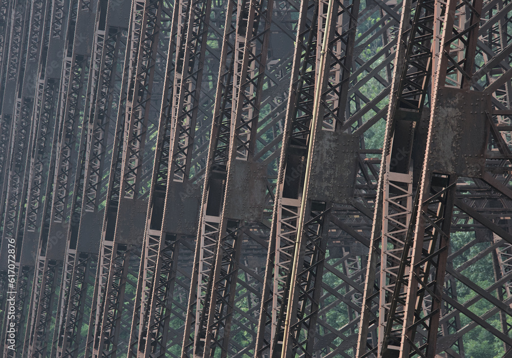 geometric pattern of crossing rusty steel beams under a railroad ...