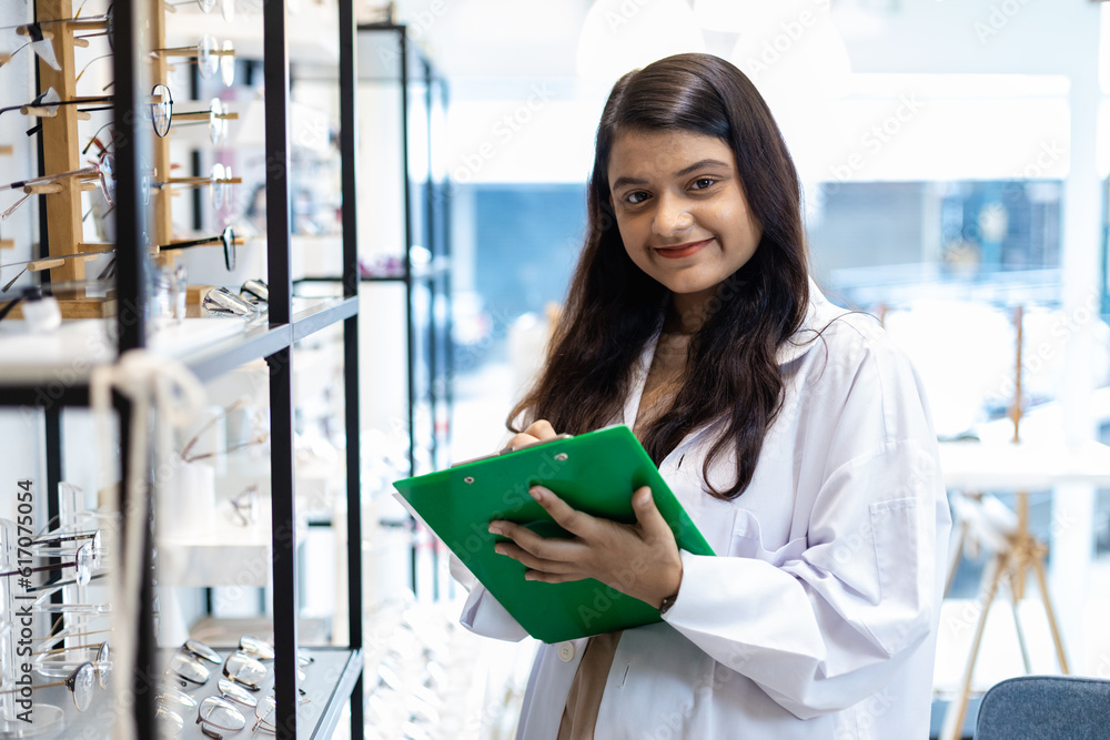 Indian woman professional optician selling checking details of glasses ...
