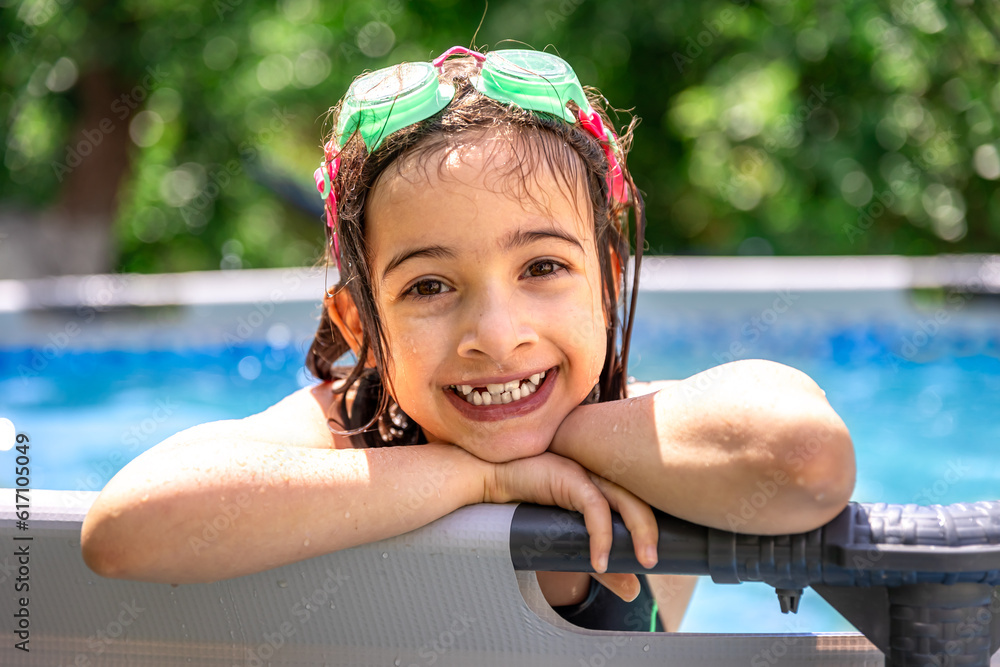 Little girl playing in a swimming pool at a summer garden. Stock Photo ...