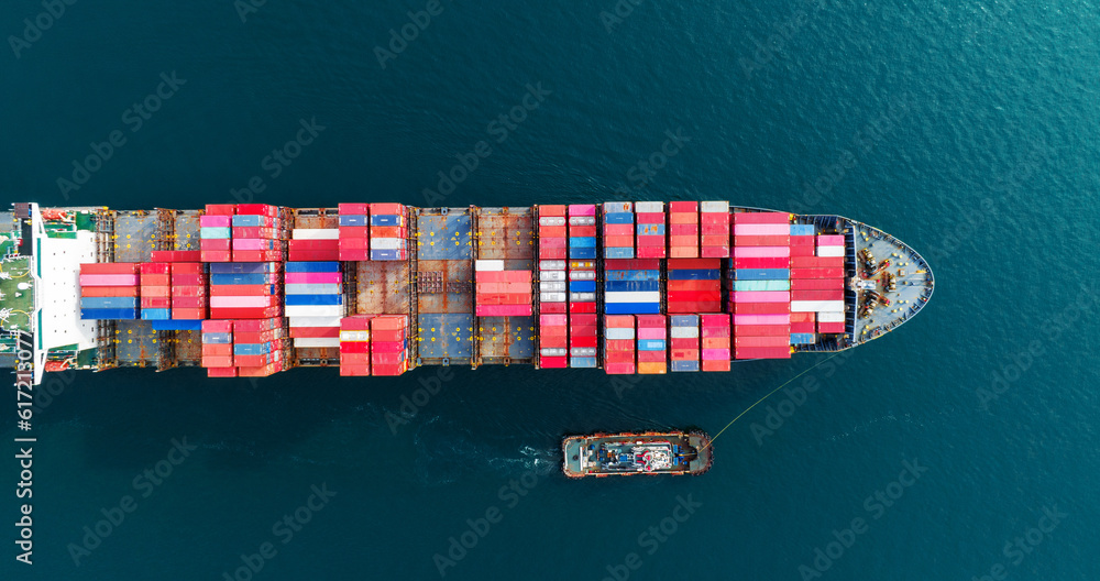 Aerial top view of cargo ship carrying container and running with tug ...