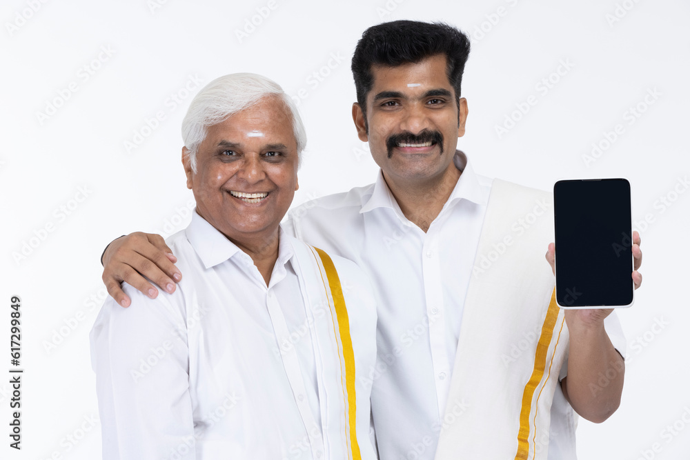 Portrait of smiling south indian father and son in traditional clothing ...