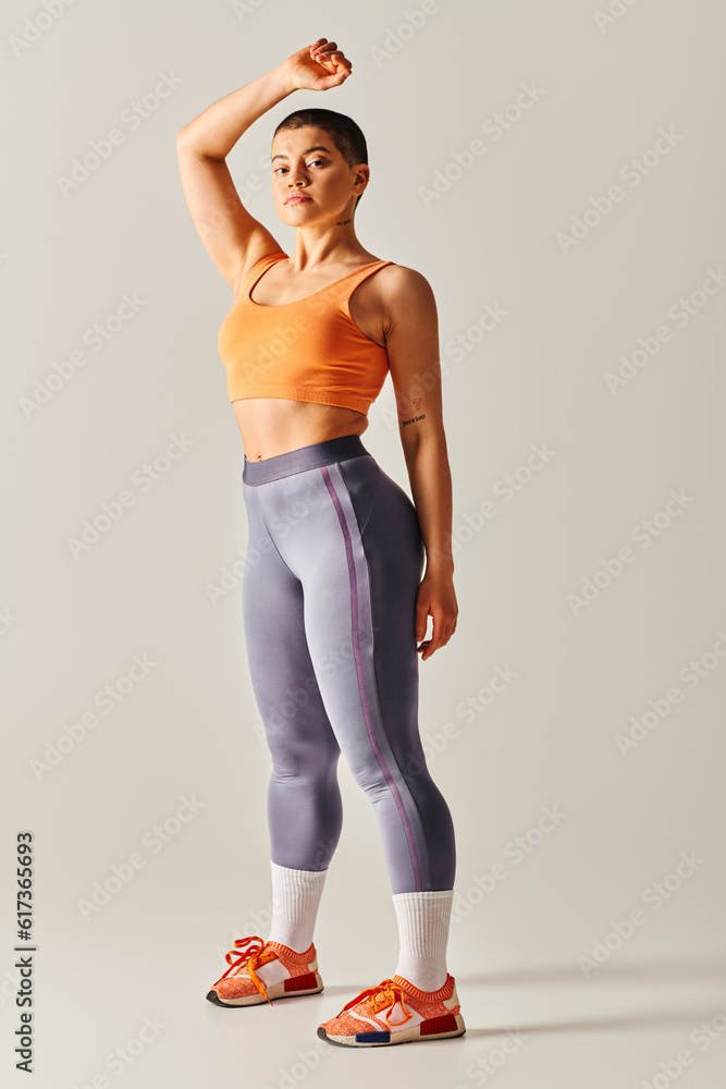 body confidence, athletic and short haired woman posing on grey ...