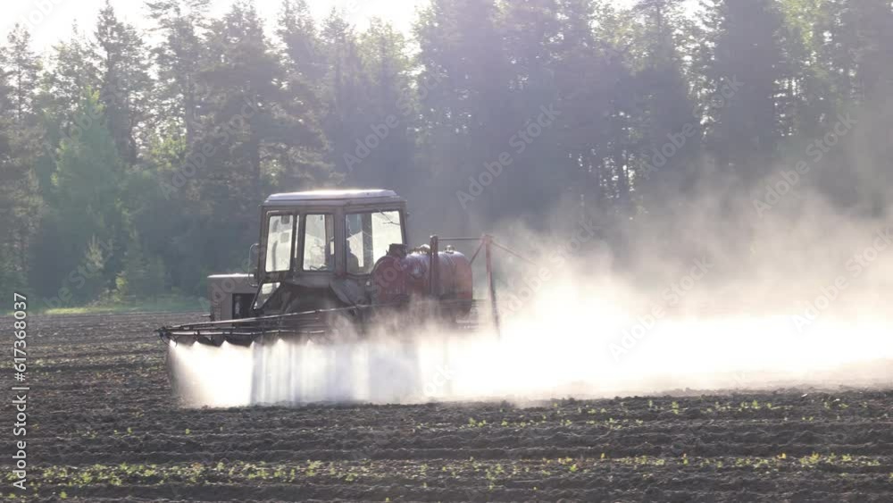 Weeds controlled with herbicide being sprayed from spray arms of ...