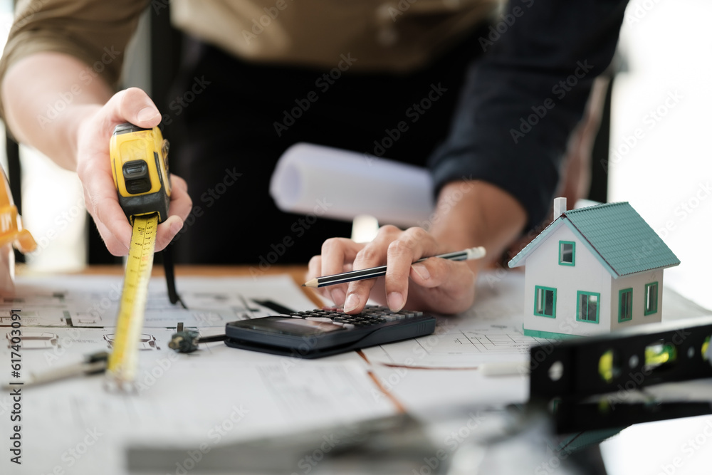 Engineers consulting team close up to design building blueprints paper ...