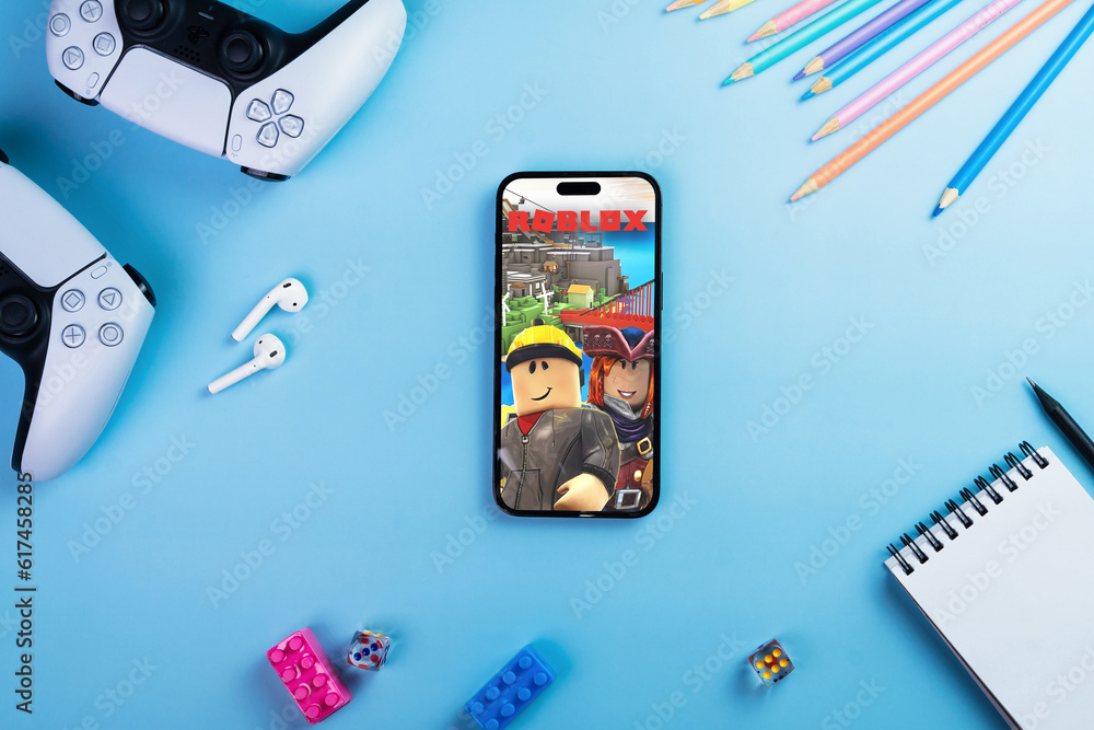 Roblox game app on the smartphone iPhone 14 Pro screen on blue table ...