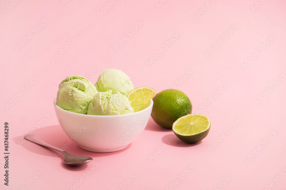 Ice cream with lime flavor and slices of fresh lime in a white bowl ...