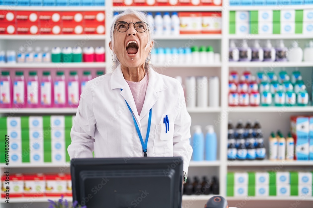 Middle age woman with tattoos working at pharmacy drugstore angry and ...