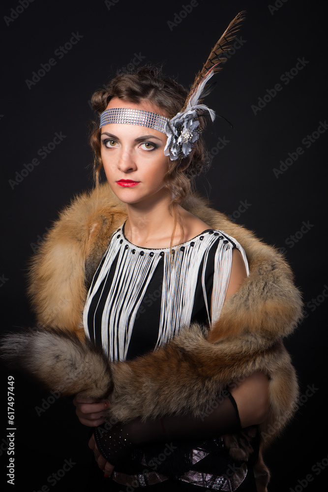 The magnificent girl with a skin of a fox on shoulders and a feather in ...