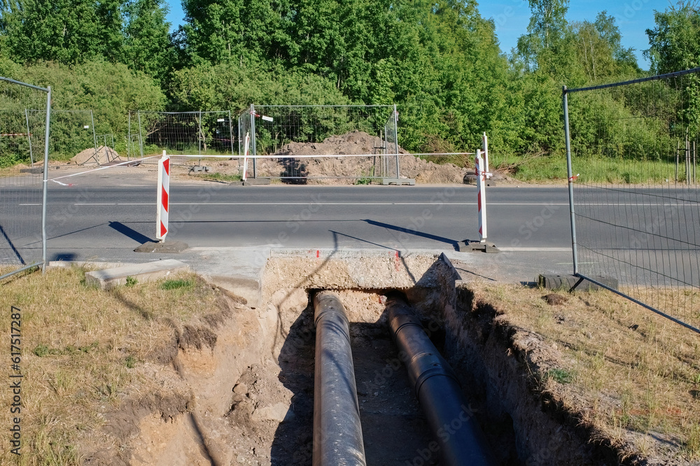 Construction of a new heating main under the road..Installing the pipe ...