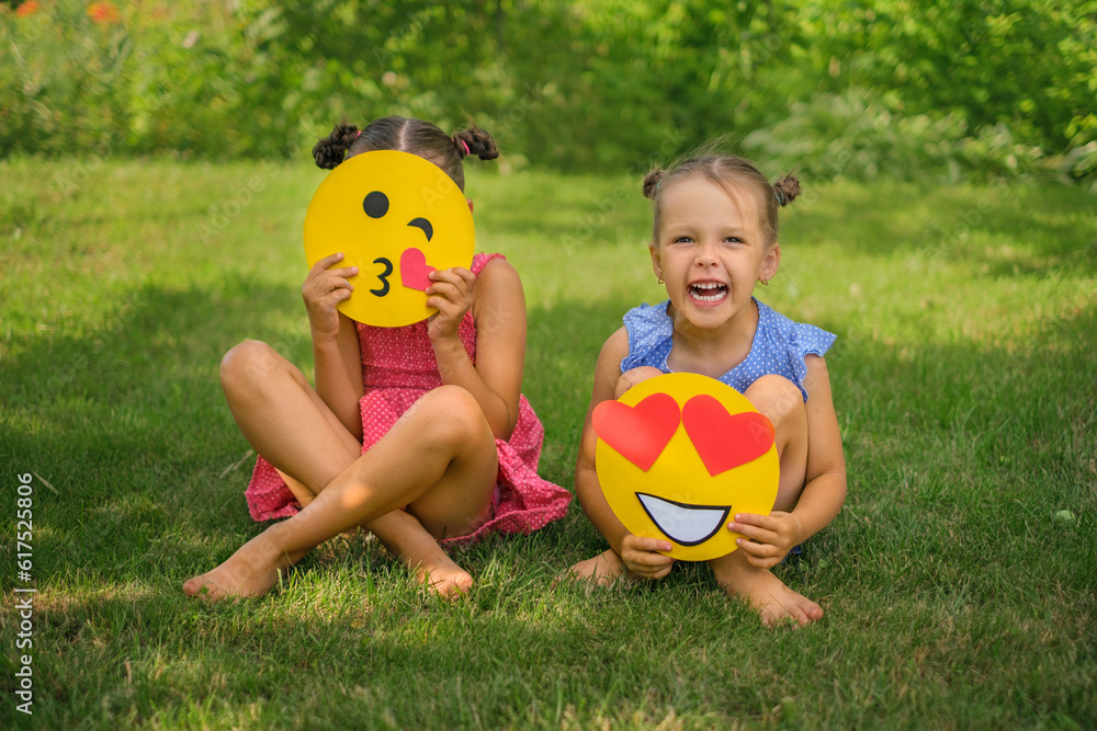 Hilariously laughing children are sitting in the park on the lawn with ...