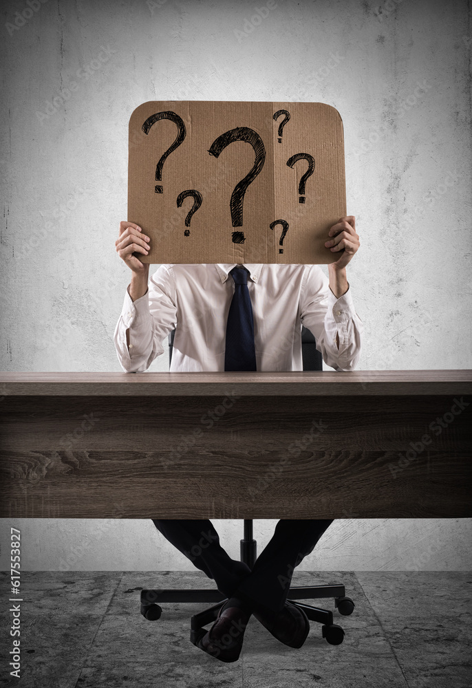 Businessman in the office holds a cardboard with question marks Stock ...