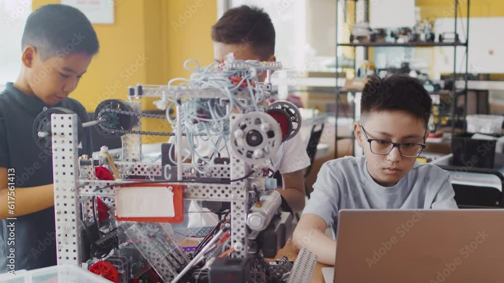 Group of multinational schoolchildren working on laptop, studying and ...