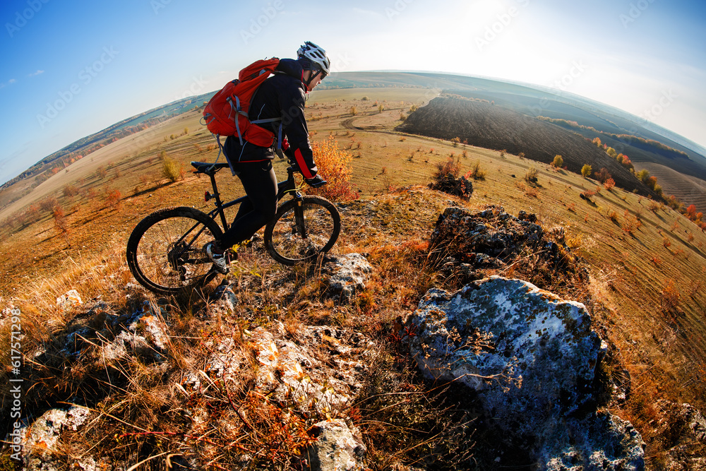 Wide angle view of a cyclist riding a bike on a nature trail in the ...