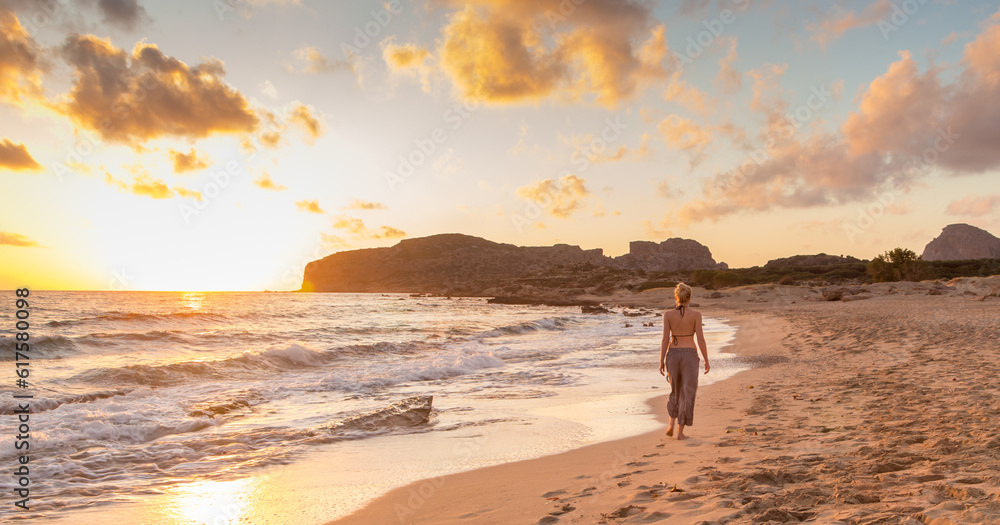 Woman walking on sandy beach at golden hour. Seashore sunset walk ...