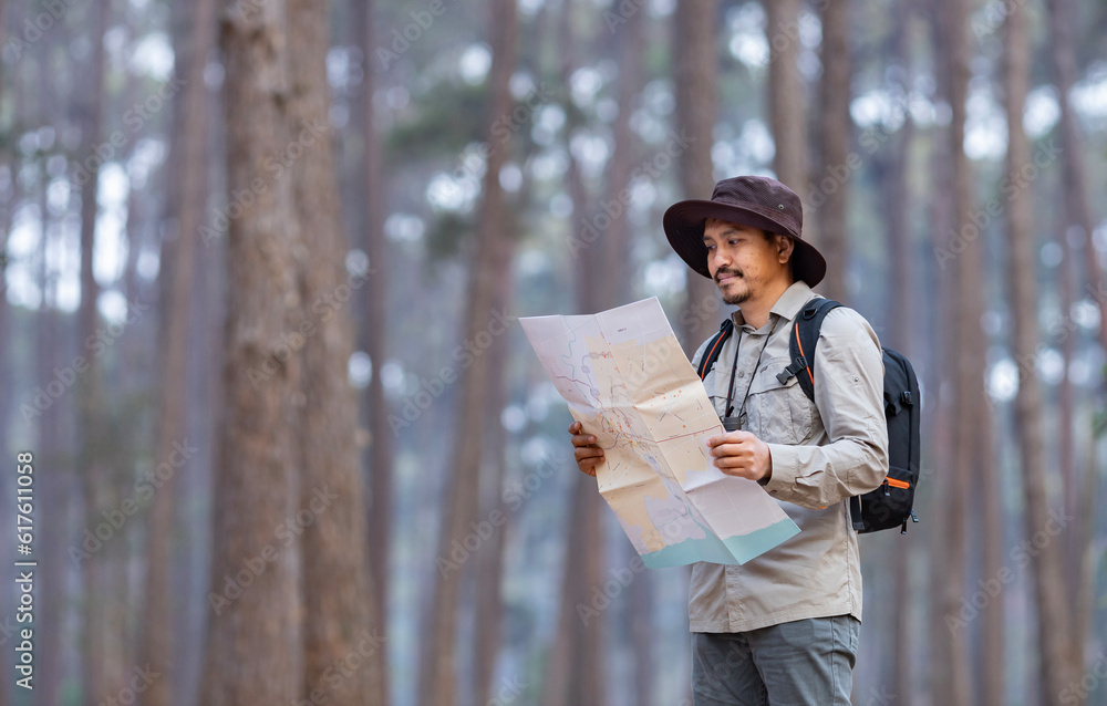 Asian naturalist looking at the map for direction while exploring ...