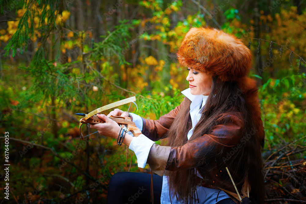Girl in a leather jacket, a big red fox fur hat and with a crossbow in ...