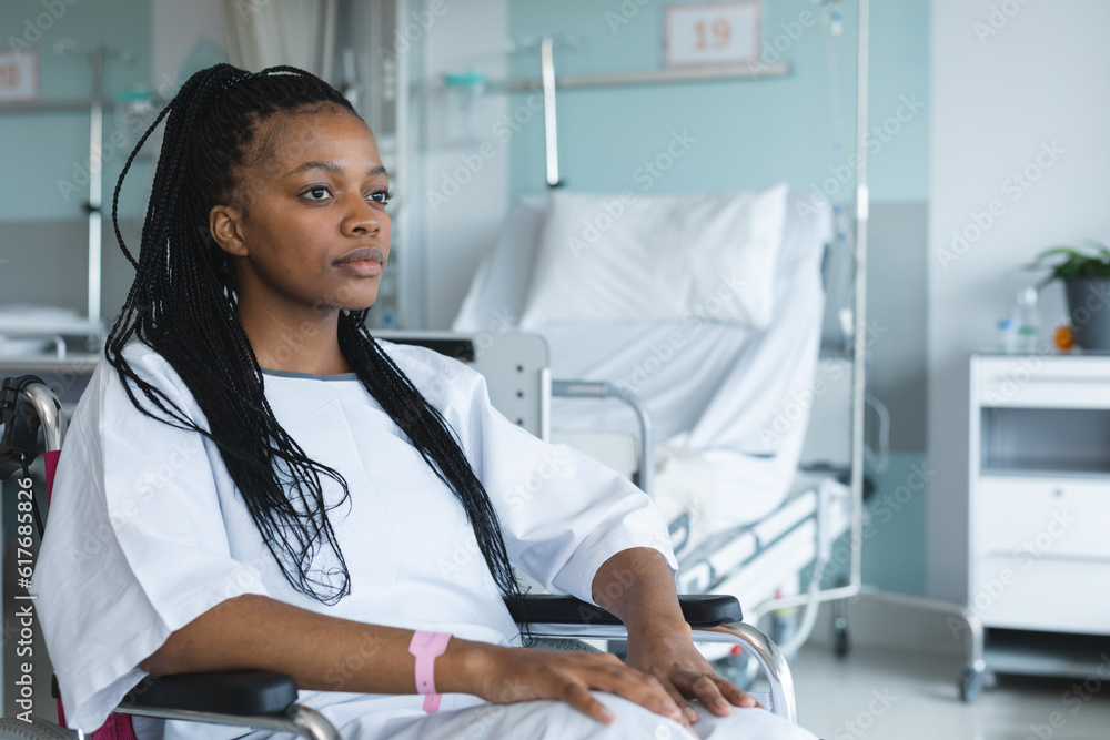 Foto de African american female patient wearing hospital gown, sitting ...