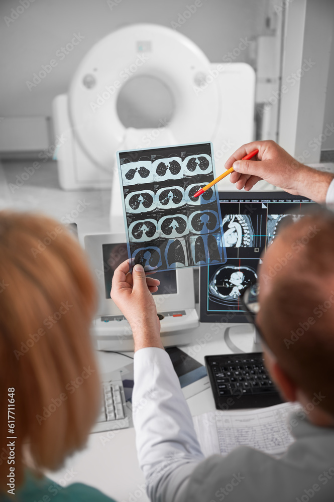Medical computed tomography or MRI scanner. Back view of doctor and ...