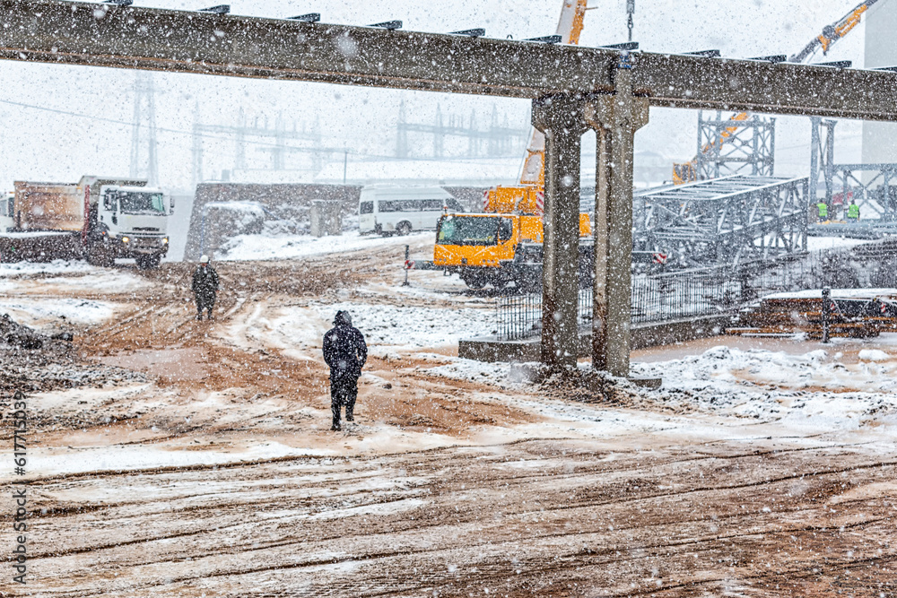 Construction site with snowy weather. Construction covers the processes ...