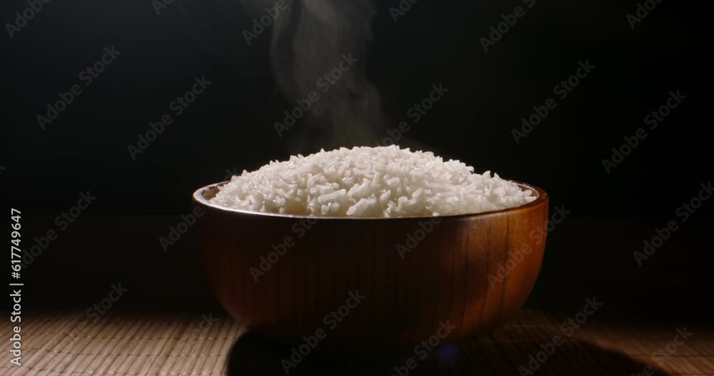 Hot white cooked rice steam bowl black background slow motion, Close up ...