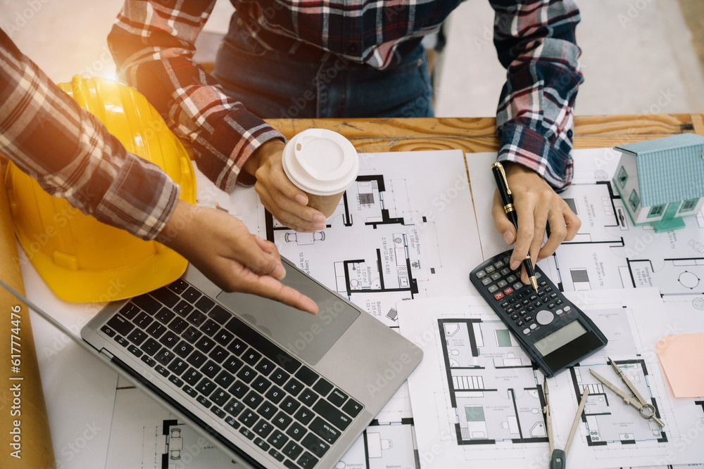 brainstorming and measuring for cost estimating on paperworks and floor ...