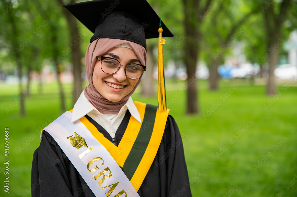 High school woman who wears a hijab a robe and graduation mortar board ...