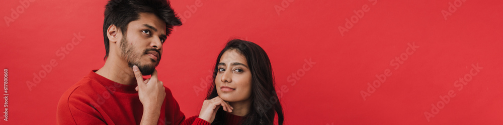 Photo & Art Print Young indian couple thinking and touching chins while ...