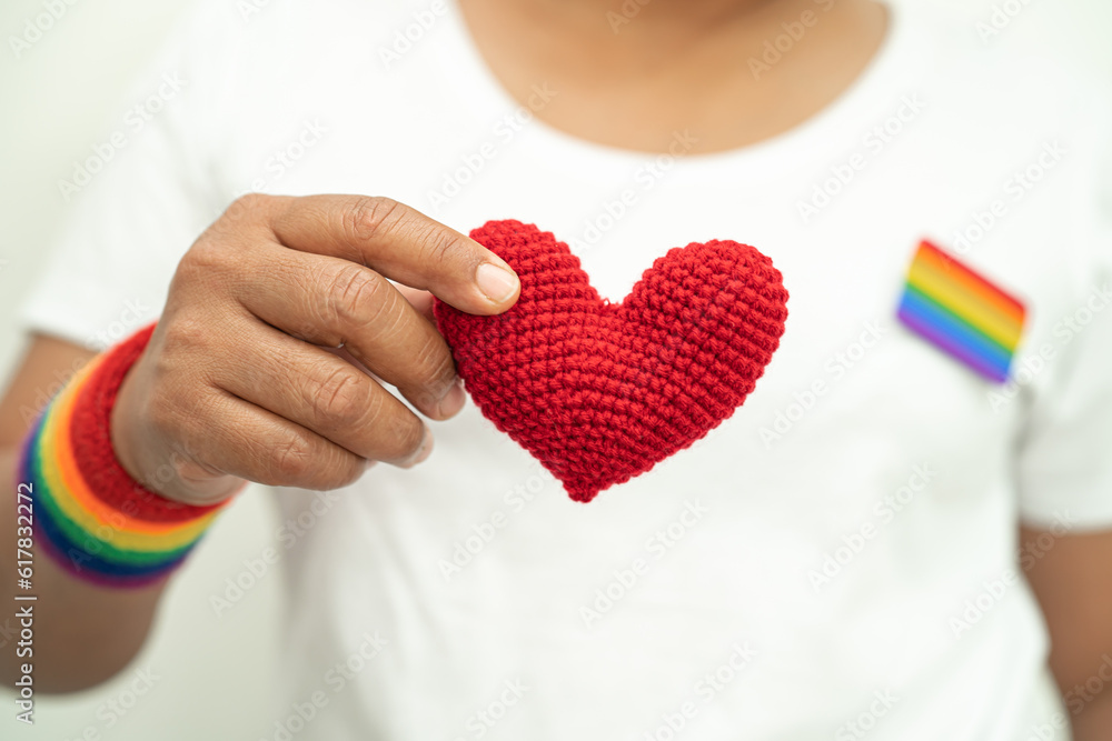 Asian lady wearing rainbow flag wristbands and hold heart, symbol of ...