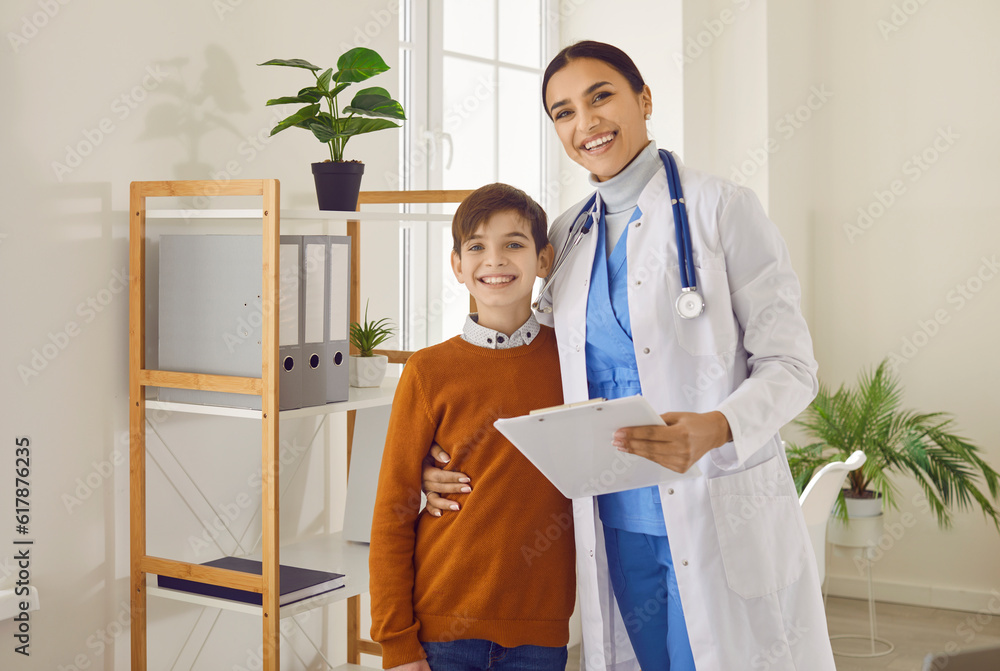 Portrait of a friendly smiling female doctor pediatrician holding ...