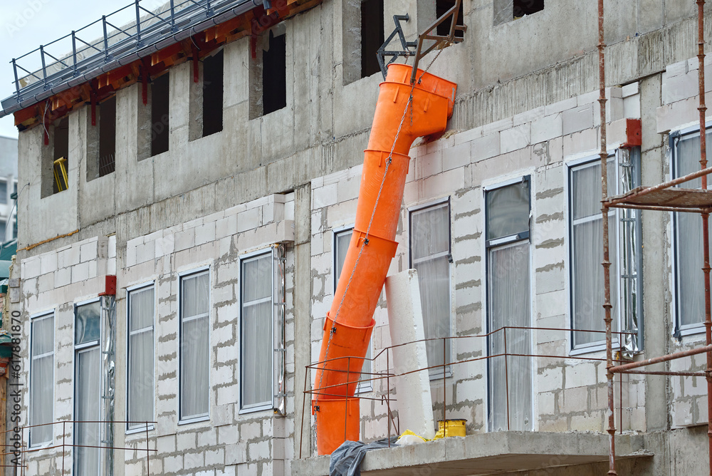 Foto de Building construction and debris chute on facade of new ...