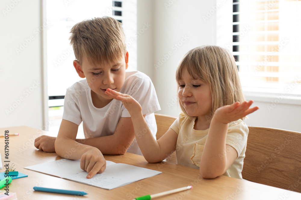 The older brother teaches the younger sister to read letters. Brother ... The older brother teaches the younger sister to read letters. Brother ...