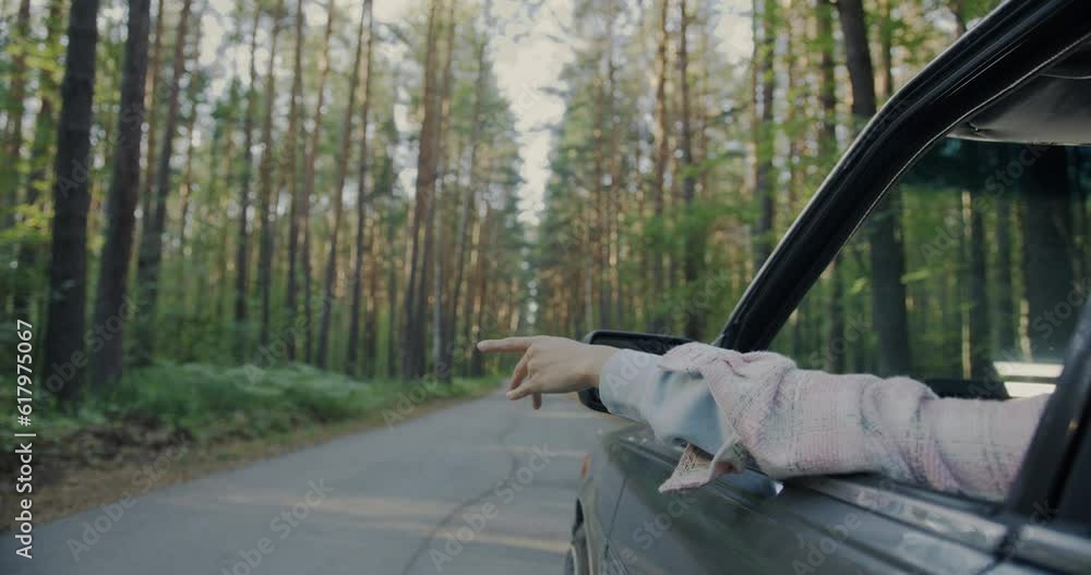 Close-up of female hand moving dancing from outside car window while ...