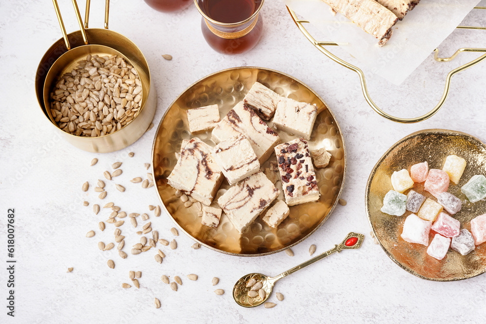 Plates with pieces of tasty marble halva and turkish delight on light ...