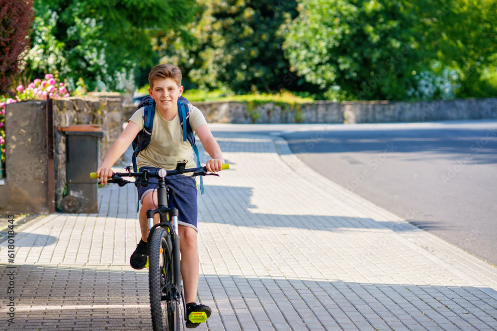 Handsome preteen boy going to school on bike. Teenager ride bicycle ...