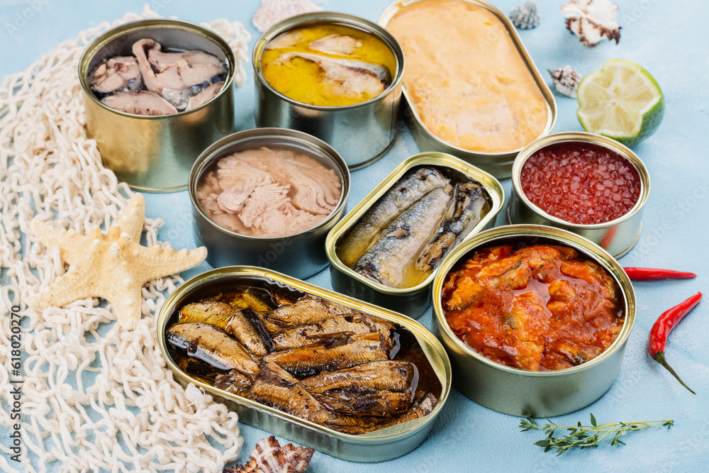 Variety of opened tins with different types of canned fish and seafood ...